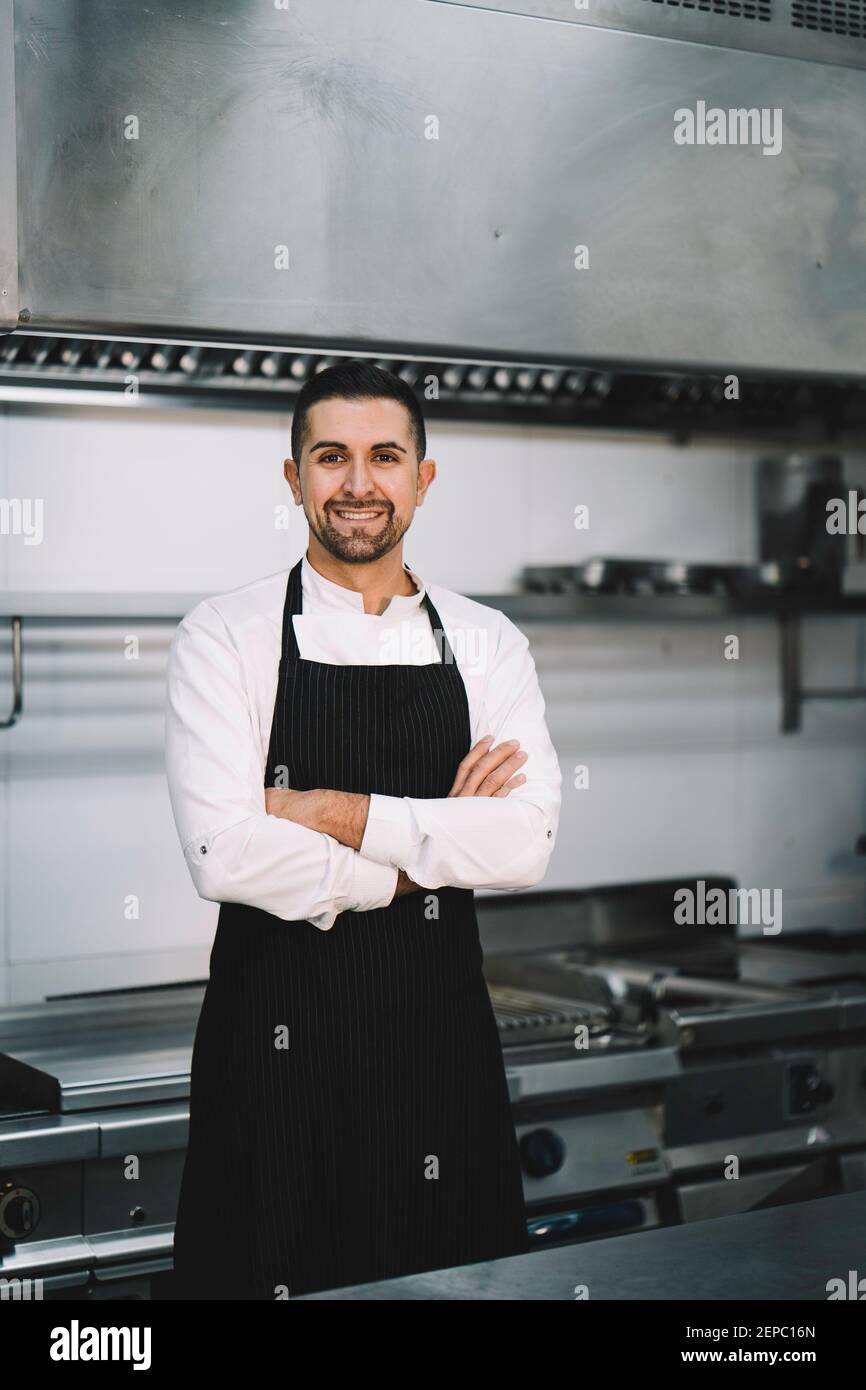 Portrait of a Professional chef posing and wearing uniform and gown in ...
