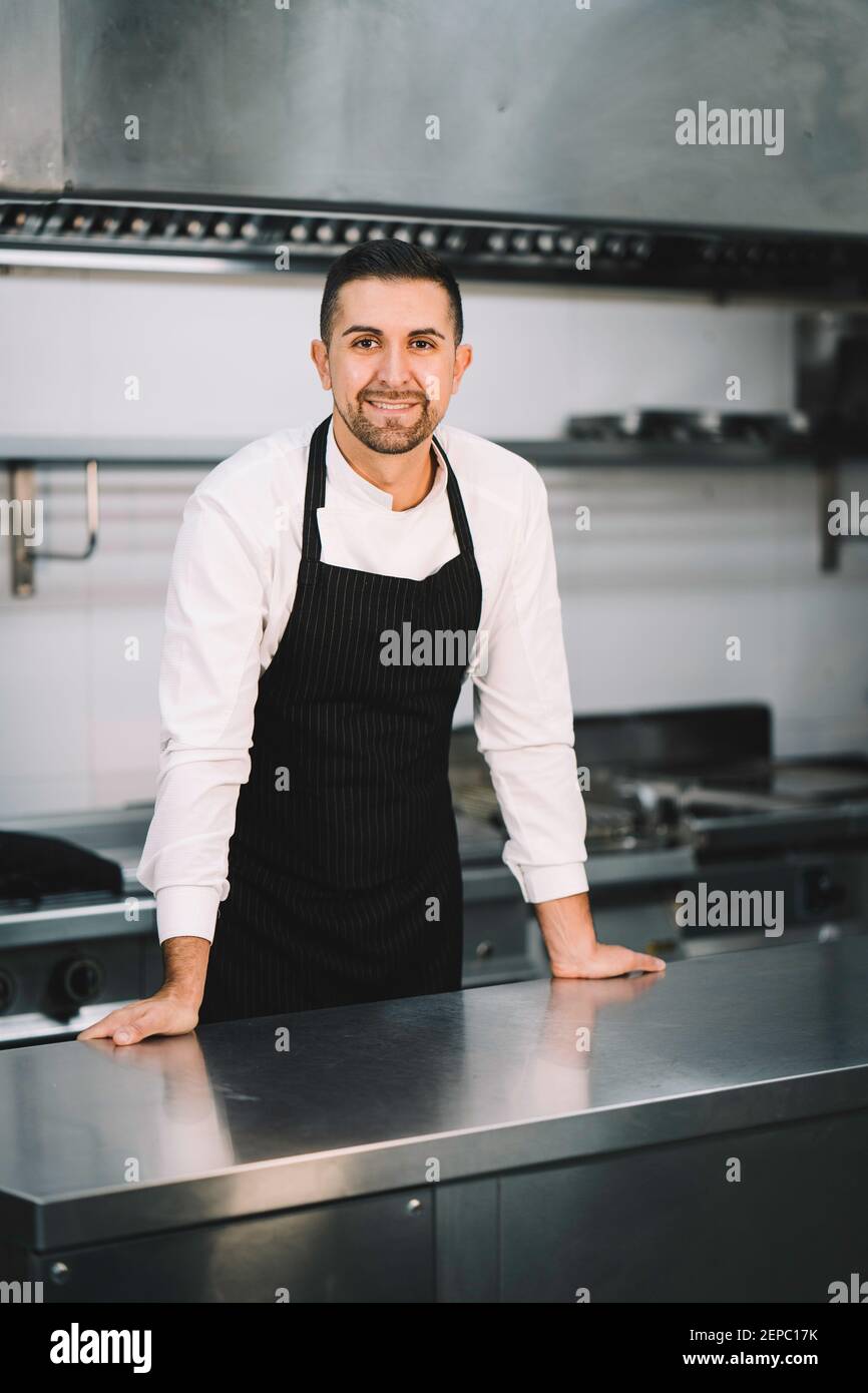 Portrait of a Professional chef posing and wearing uniform and gown in ...