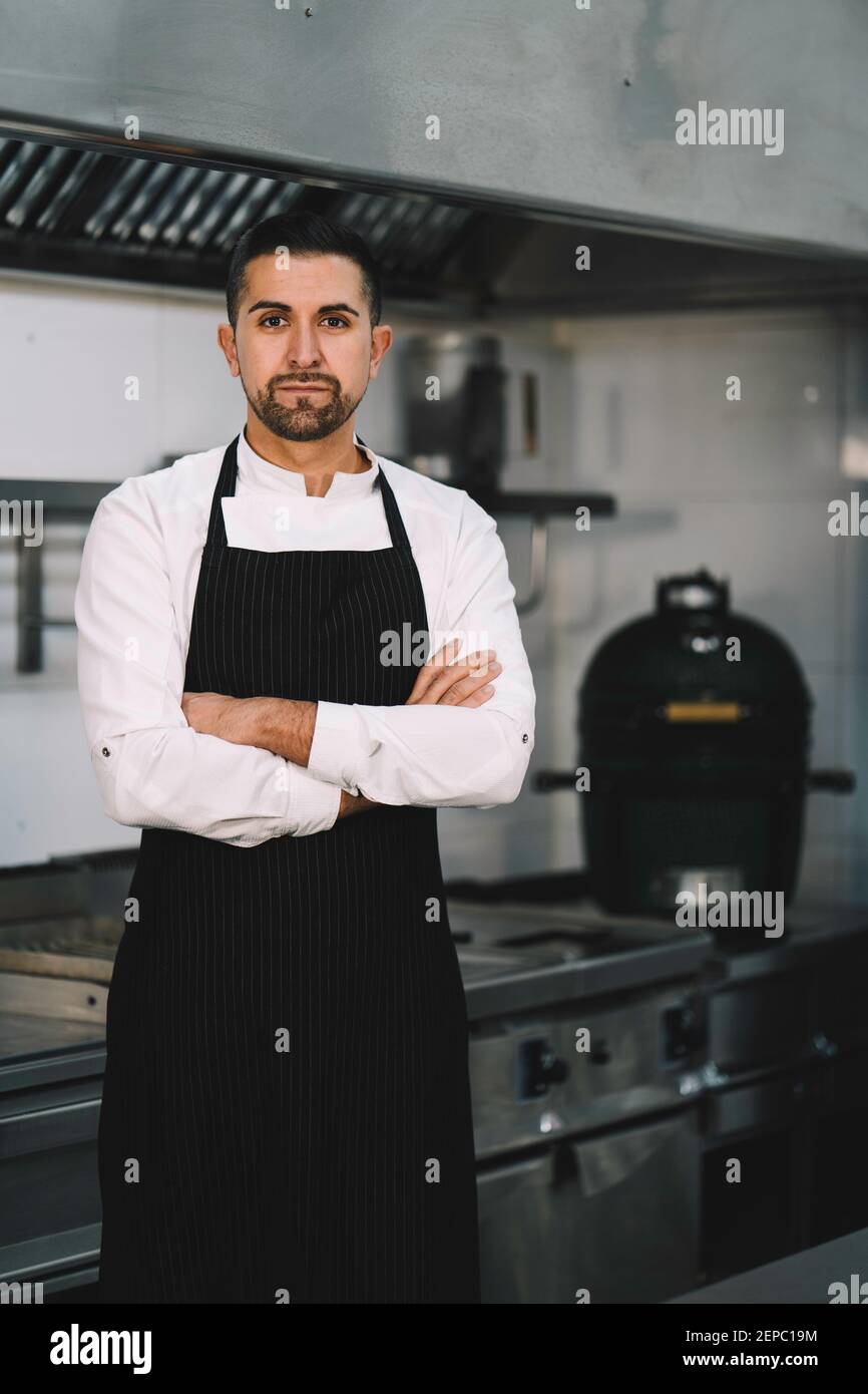 Portrait of a Professional chef posing and wearing uniform and gown in ...