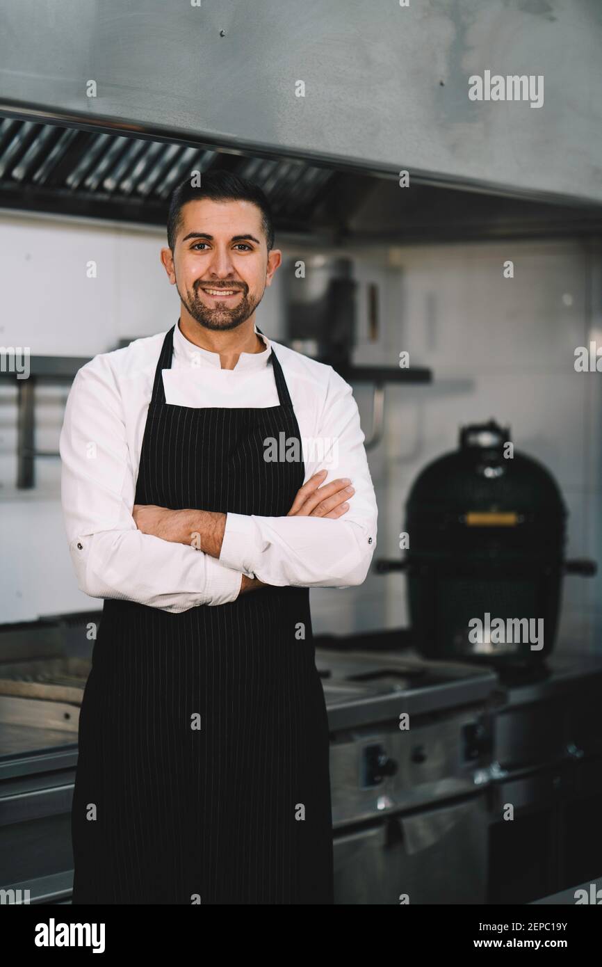 Portrait of a Professional chef posing and wearing uniform and gown in ...