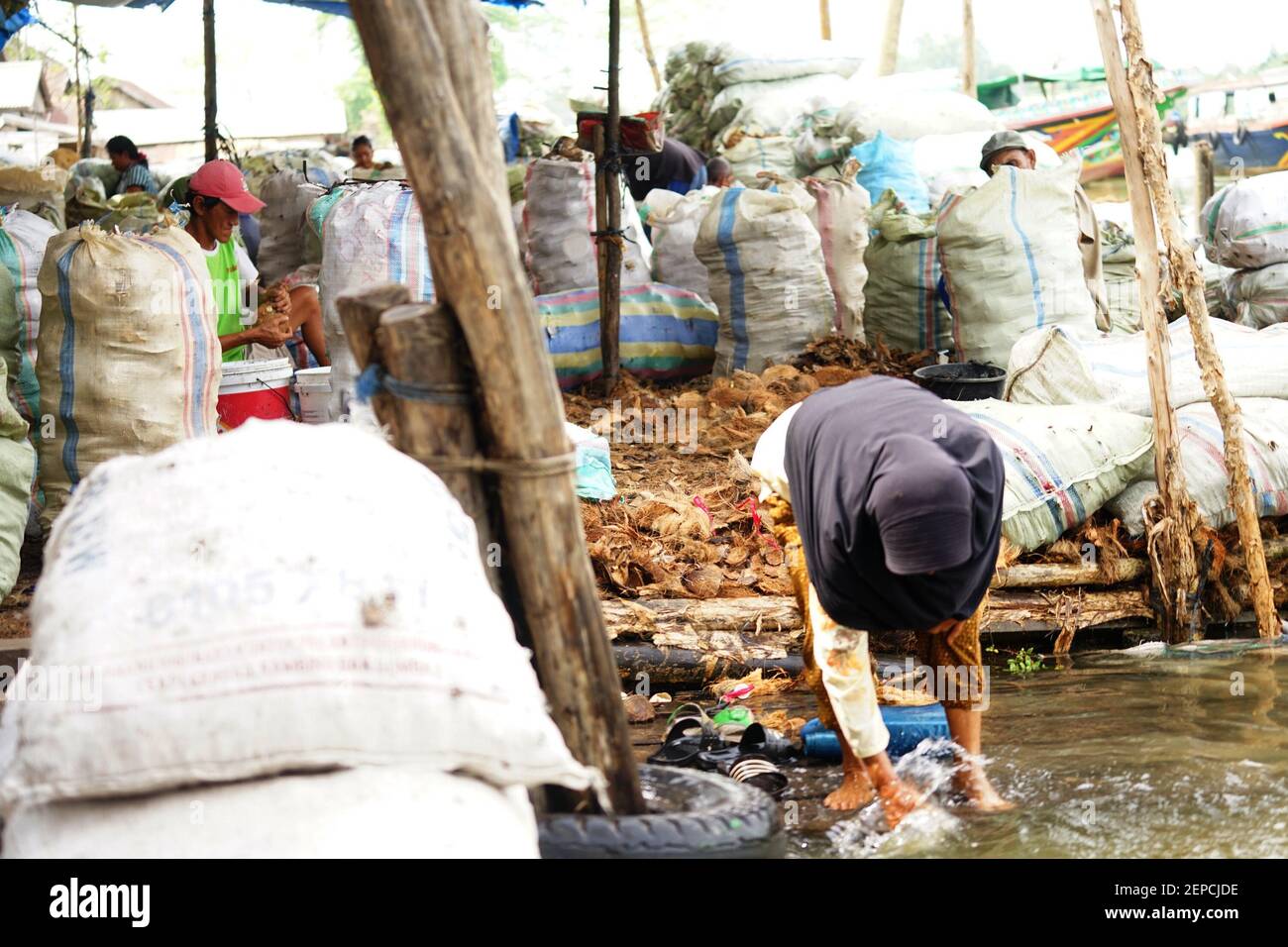 A resident cleans coconut shells before process of making shell ...