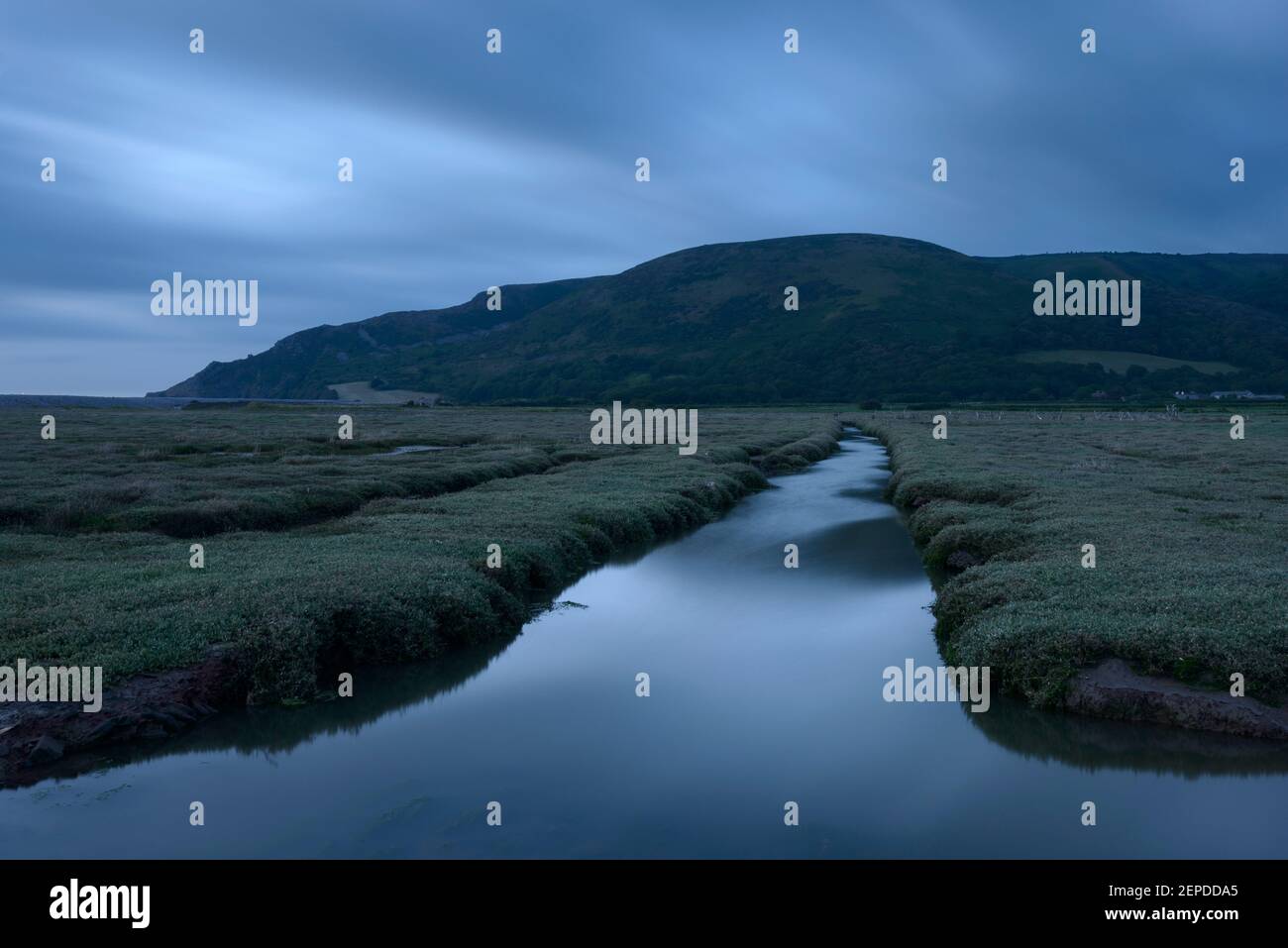 Water flowing through a salt marsh leading to Bossington Hill, Somerset ...