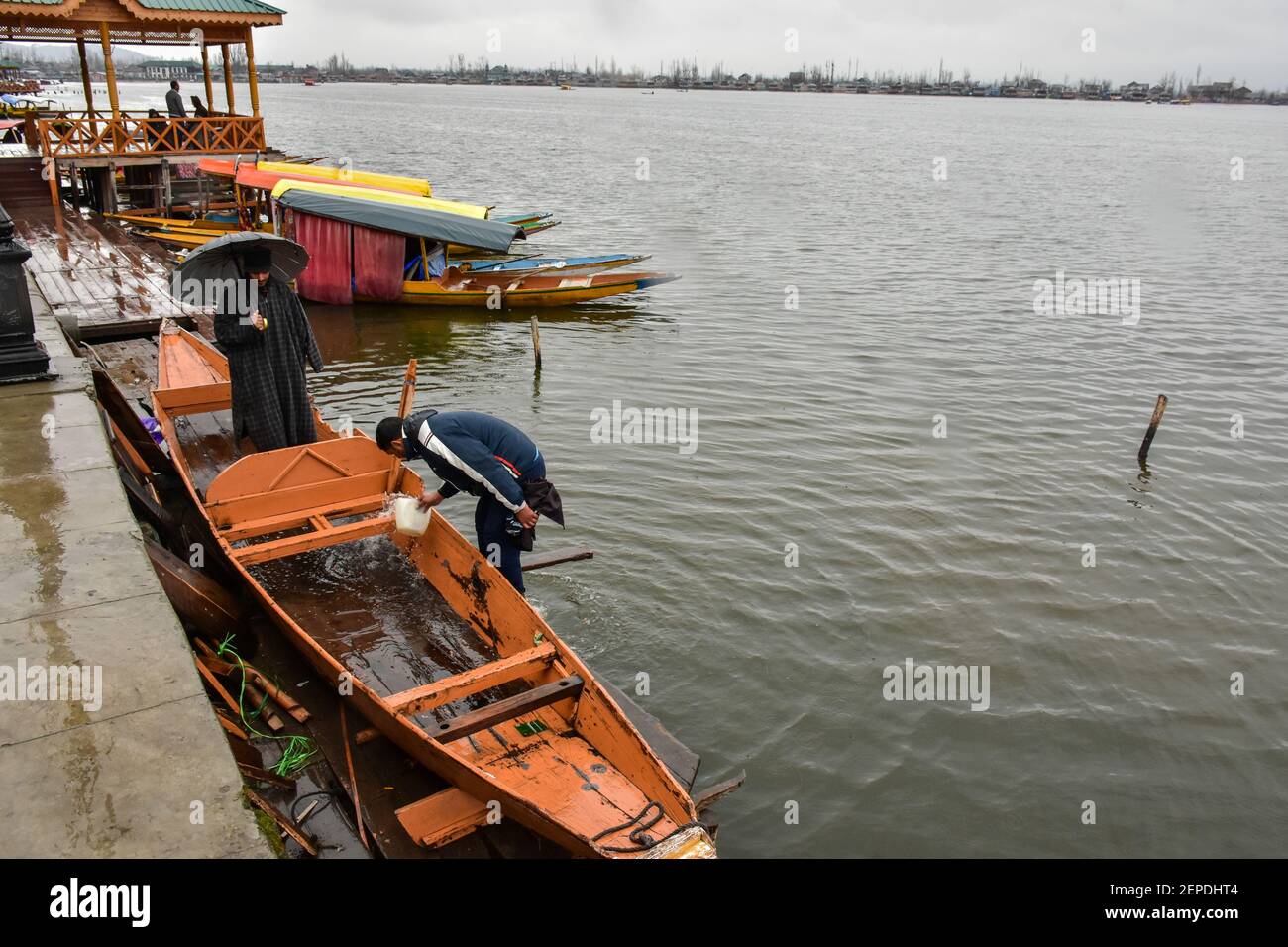 A boatman removes water from his boat during rainfall in Srinagar.Rain ...