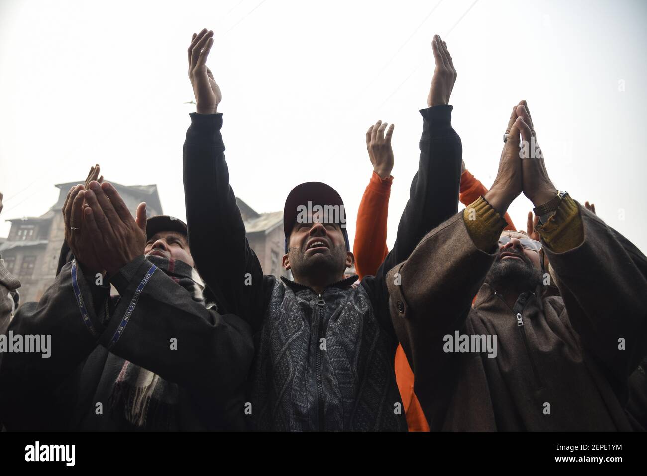 Kashmiri Muslims raise their hands while beseeching for blessings as ...