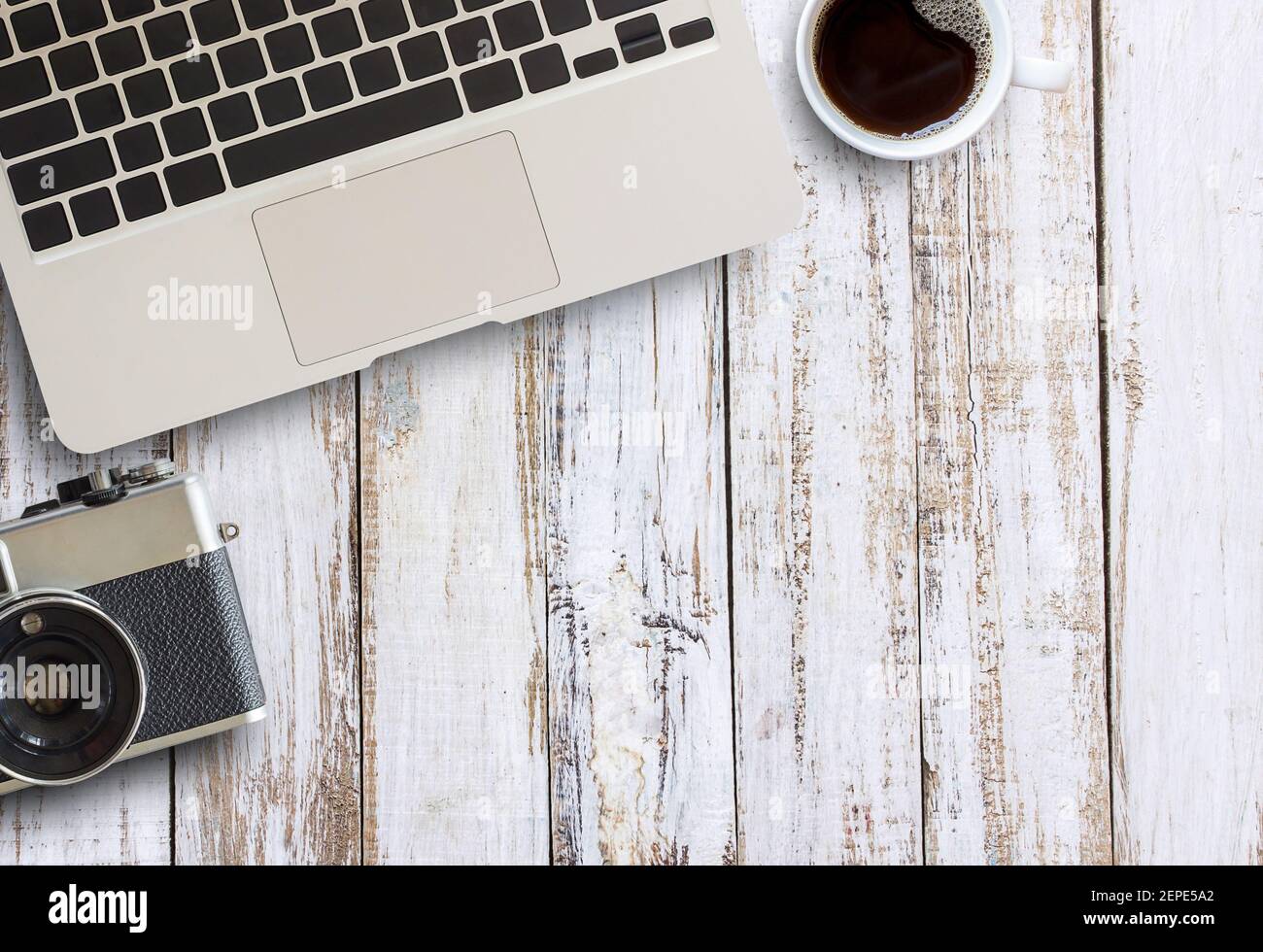 Office table with laptop computer,camera and coffee cup. View from ...
