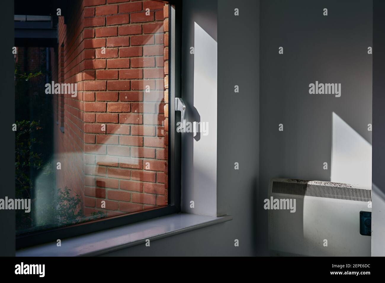 View through a window to outside brick wall with heating radiator and ...