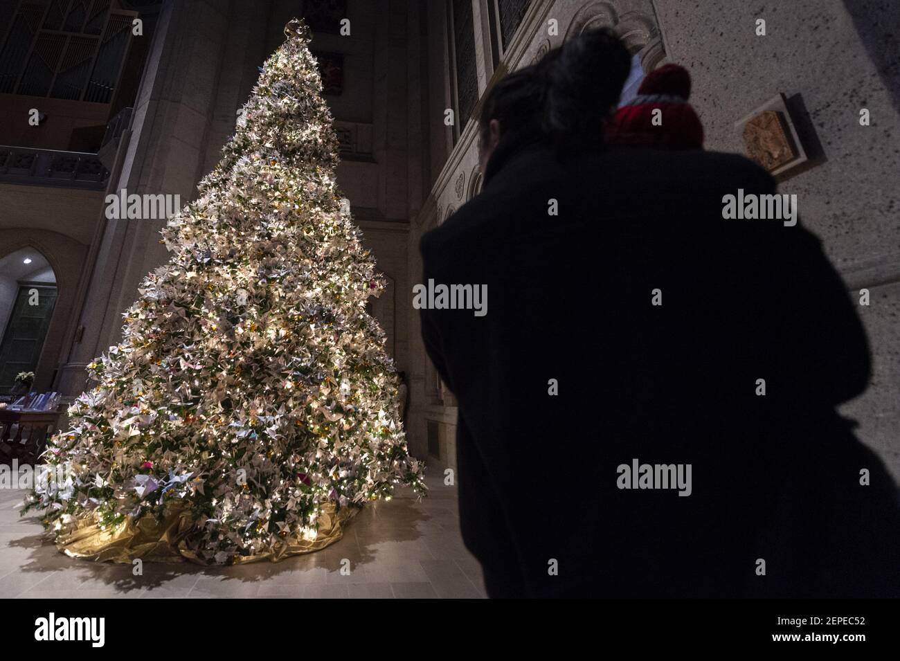 Participants of the origami Christmas tree lighting ceremony admire the ...
