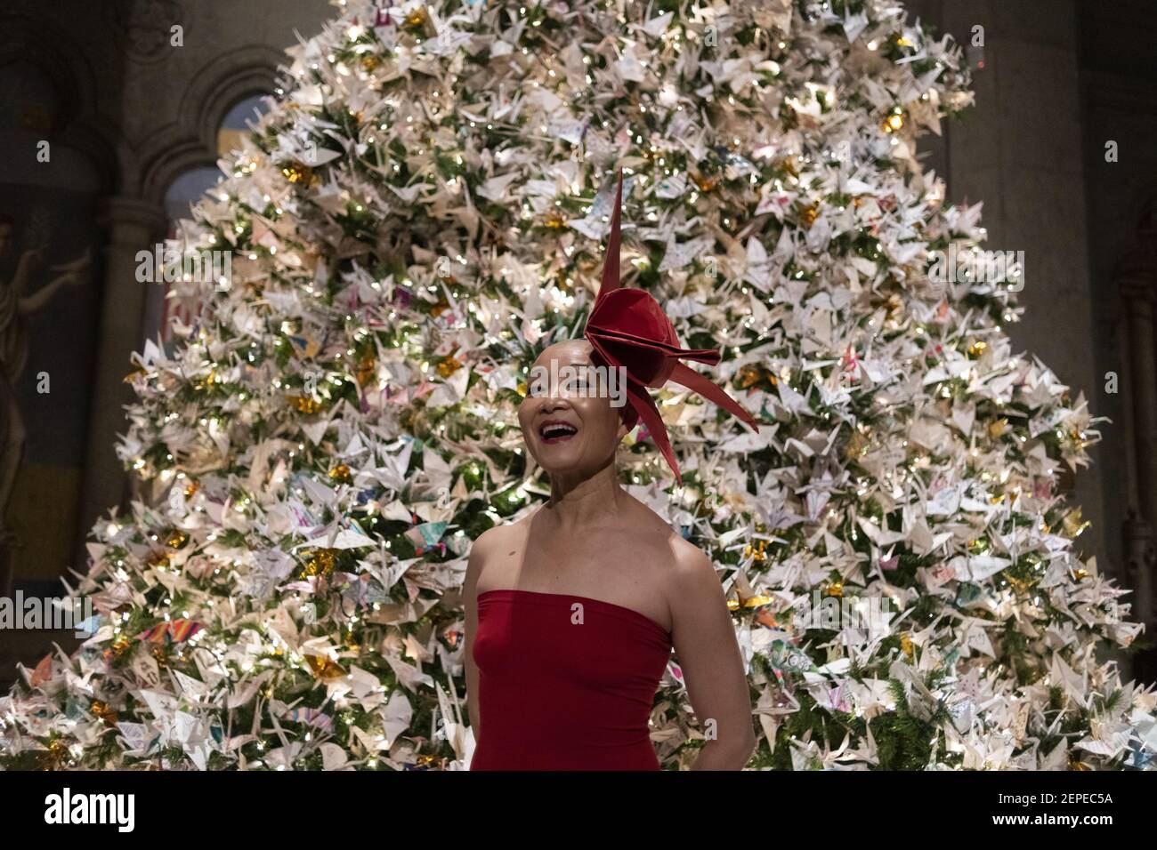 A participant of the origami Christmas tree lighting ceremony poses in ...