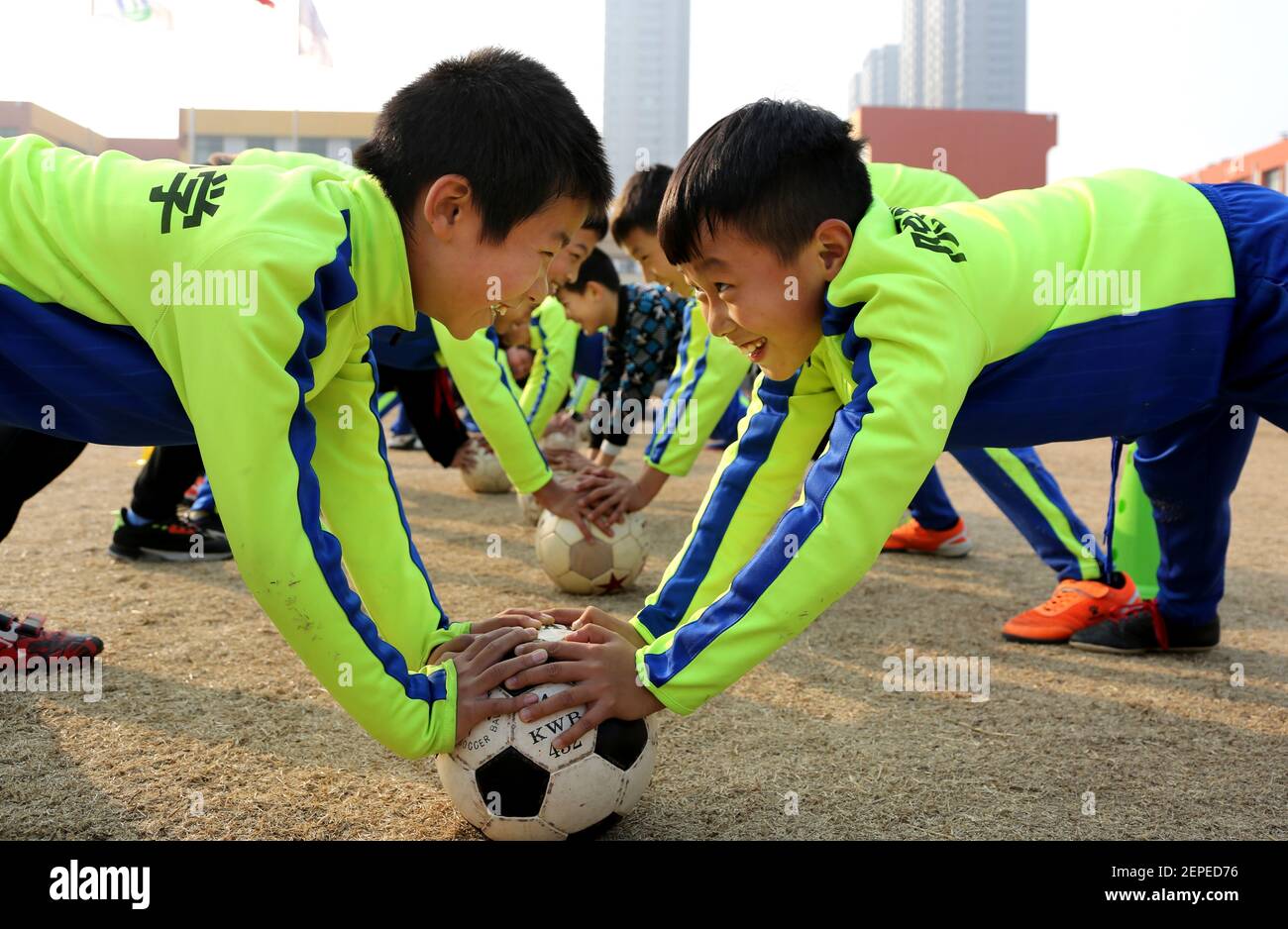 Young Chinese students practise football during a training session and ...
