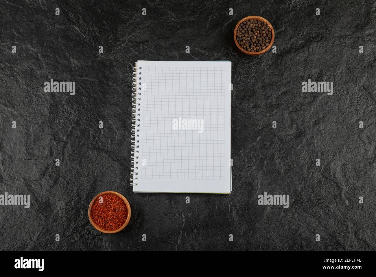 Two wooden bowls of peppercorn and pepper powder with a notebook Stock ...