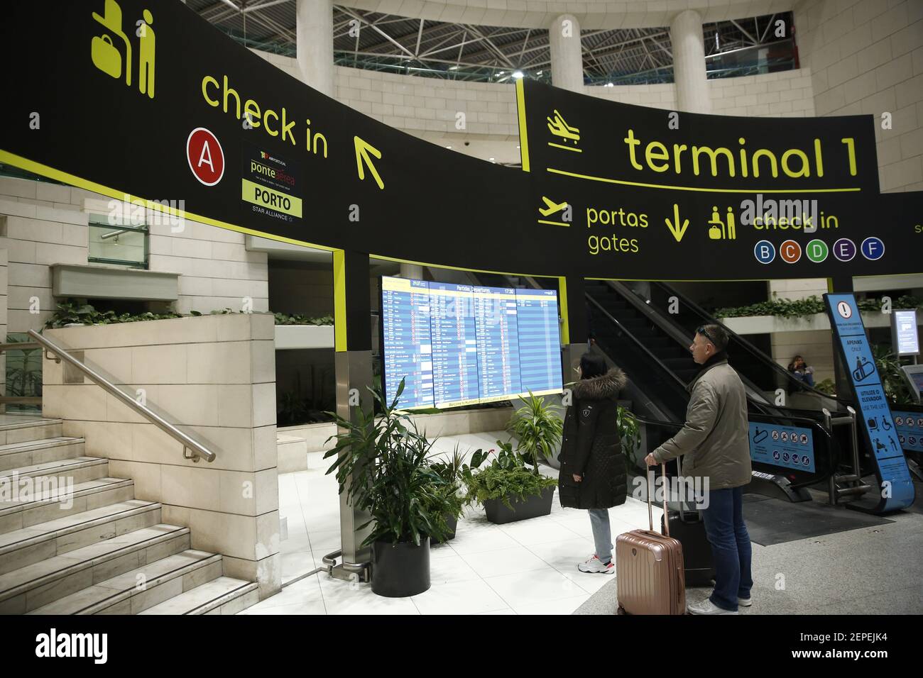 People look at the departure screen at Lisbon Portela Airport. (Photo by Sergei Mikhailichenko ...