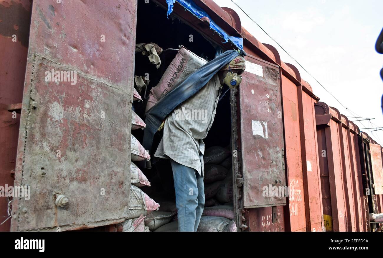 An Indian labourer unloads a cement bag from freight trains at the ...
