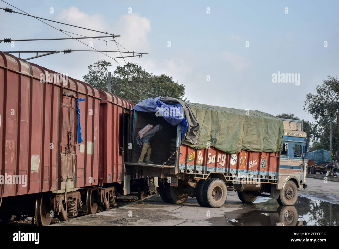 An Indian labourer unloads a cement bag from freight trains at the ...