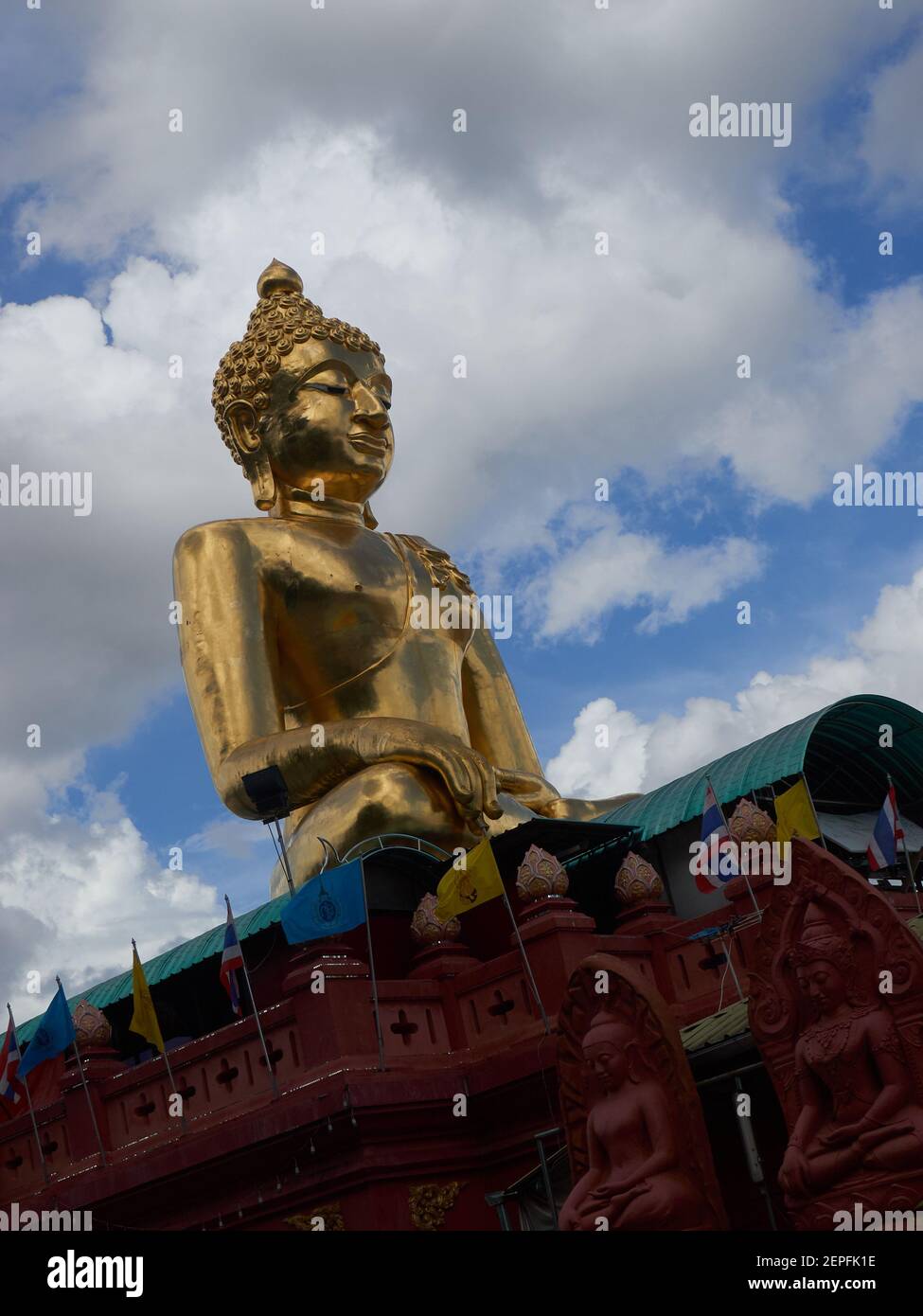 golden buddha statue on top of the temple building from below Stock ...