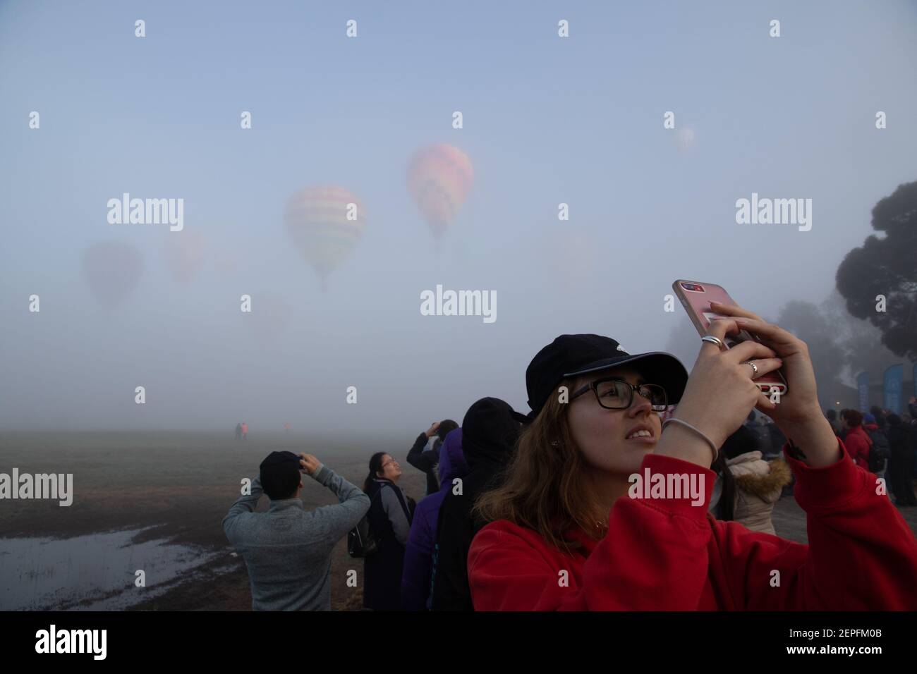 Girl taking selfie with hot air balloons in the mist Stock Photo - Alamy