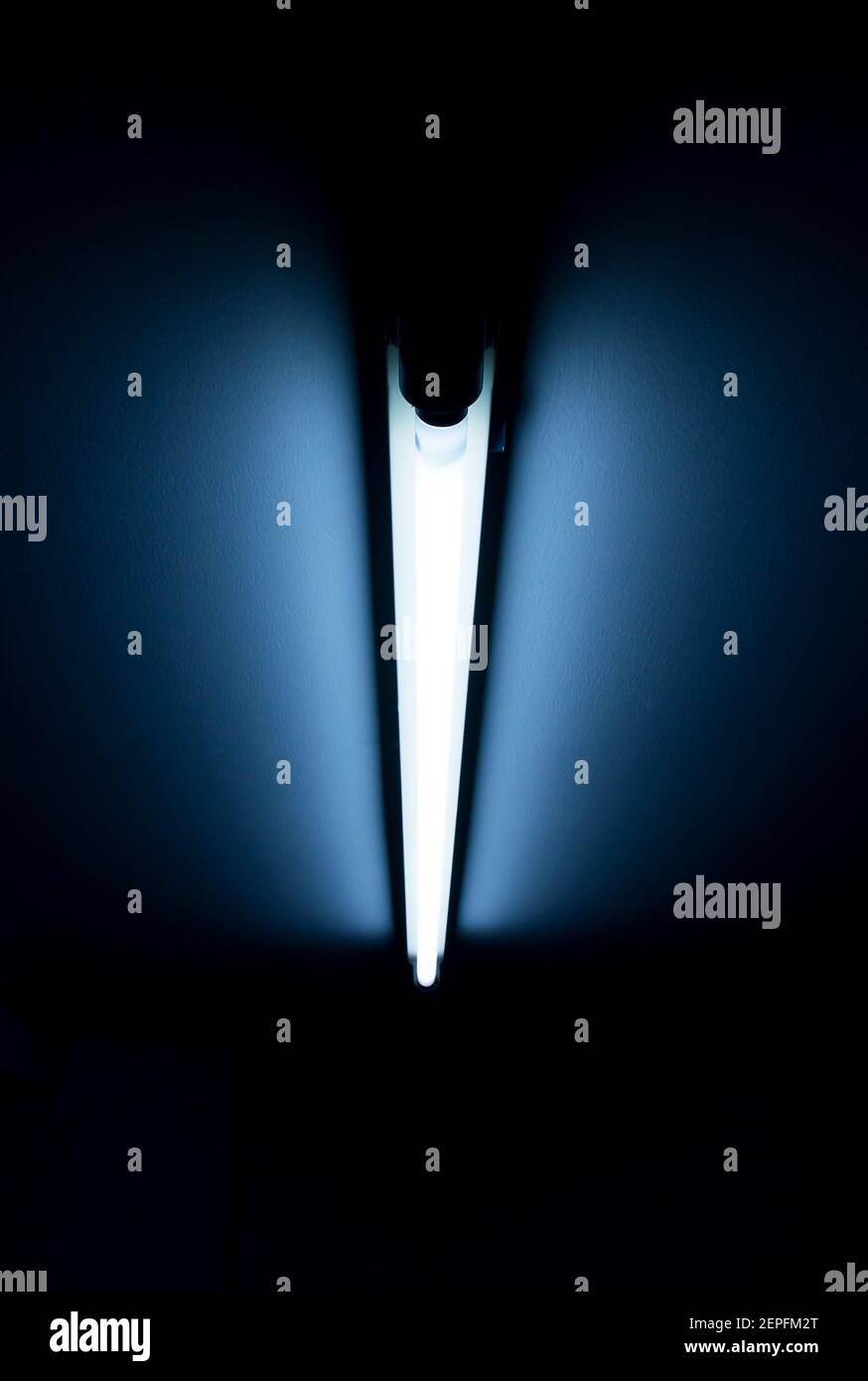 Detail of a fluorescent tube mounted on a wall, false green color light ...