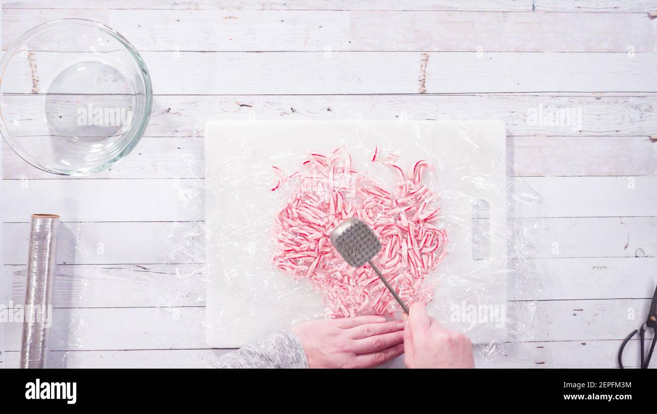 Flat lay. Step by step. Breaking candy cane candies into small pieces ...