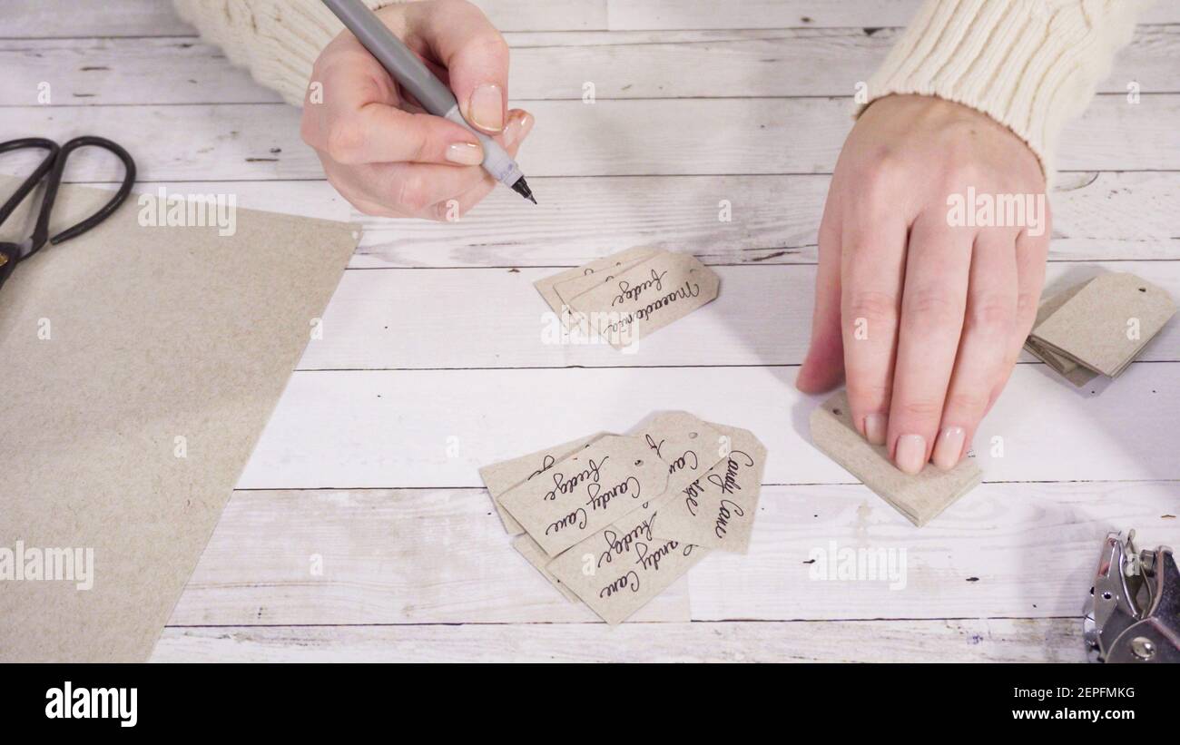 Step by step. Labeling brown paper gift tags with a black marker Stock ...