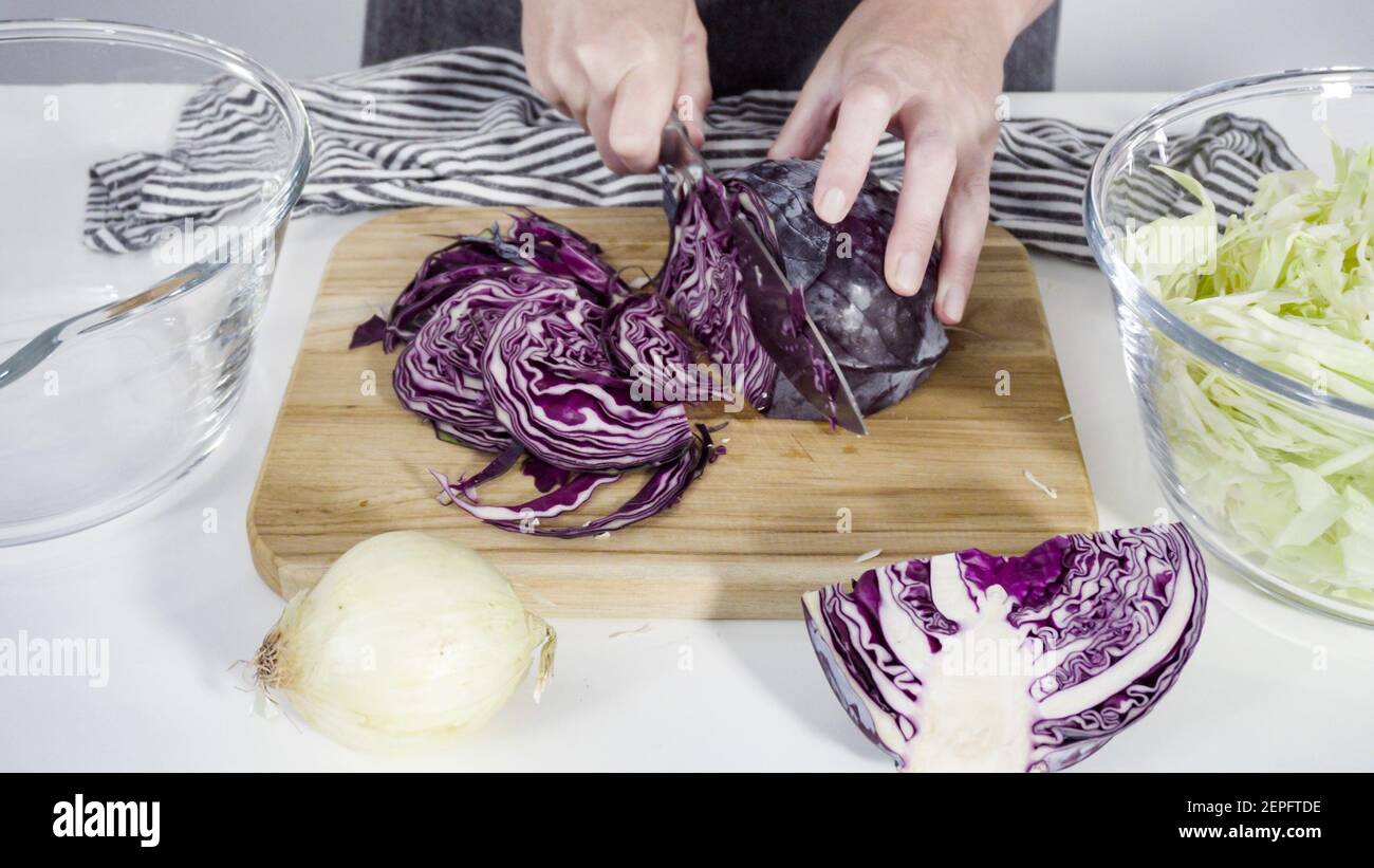 Step by step. Shredding organic cabbage on a wood cutting board Stock ...