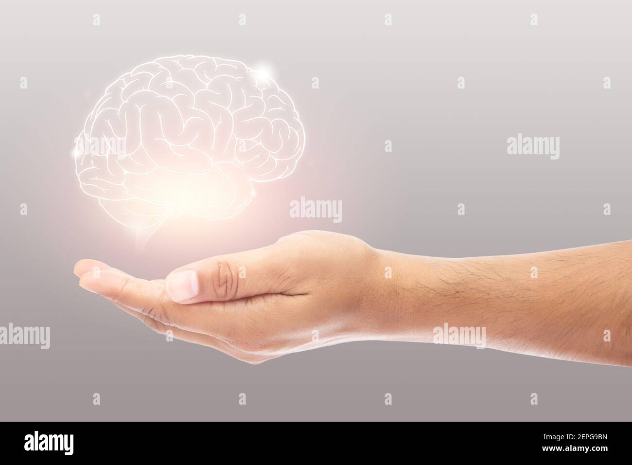 Man holding brain illustration against gray wall background. Concept ...