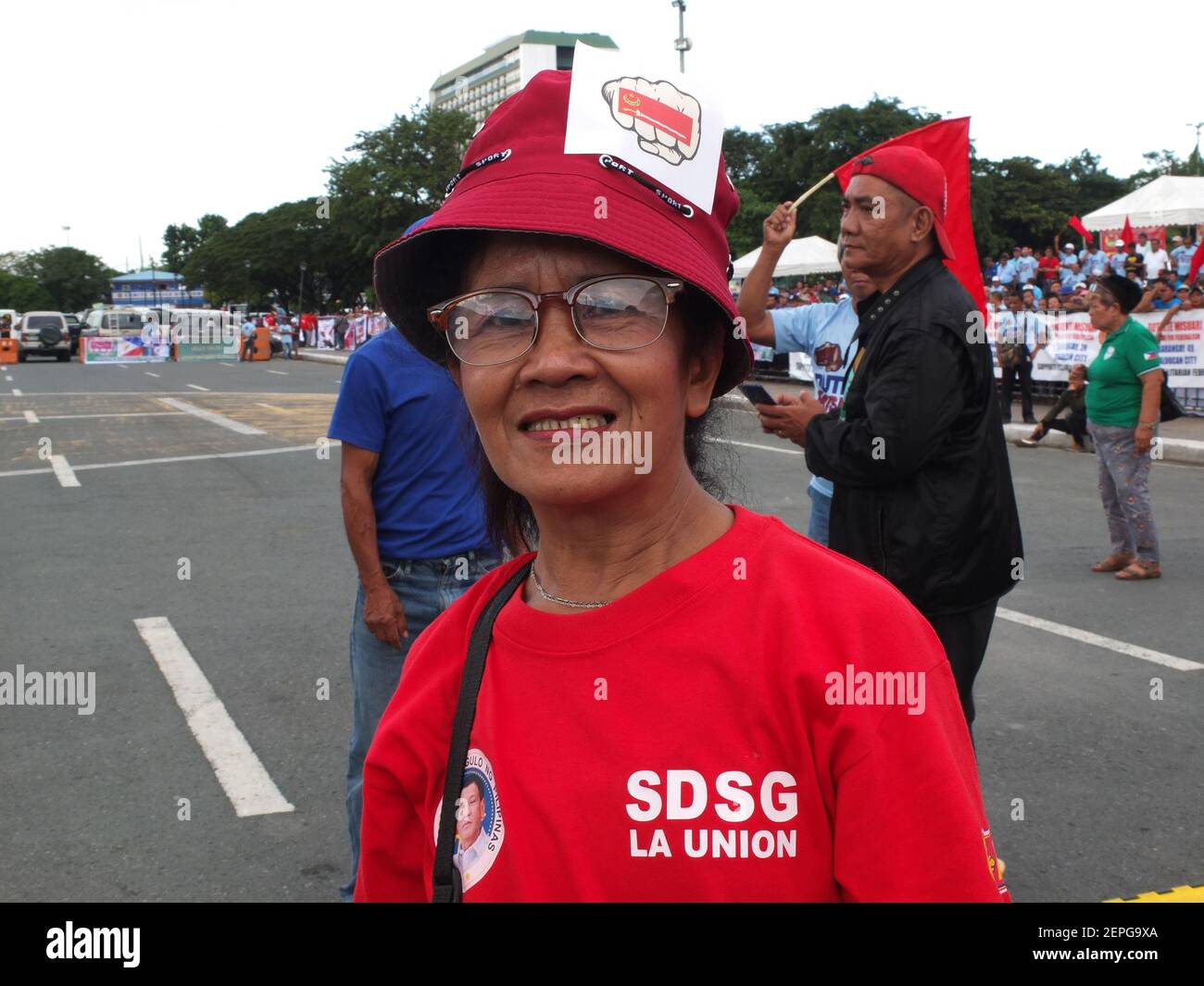 A Duterte supporter with a drawing of a fist on top of her red hat ...