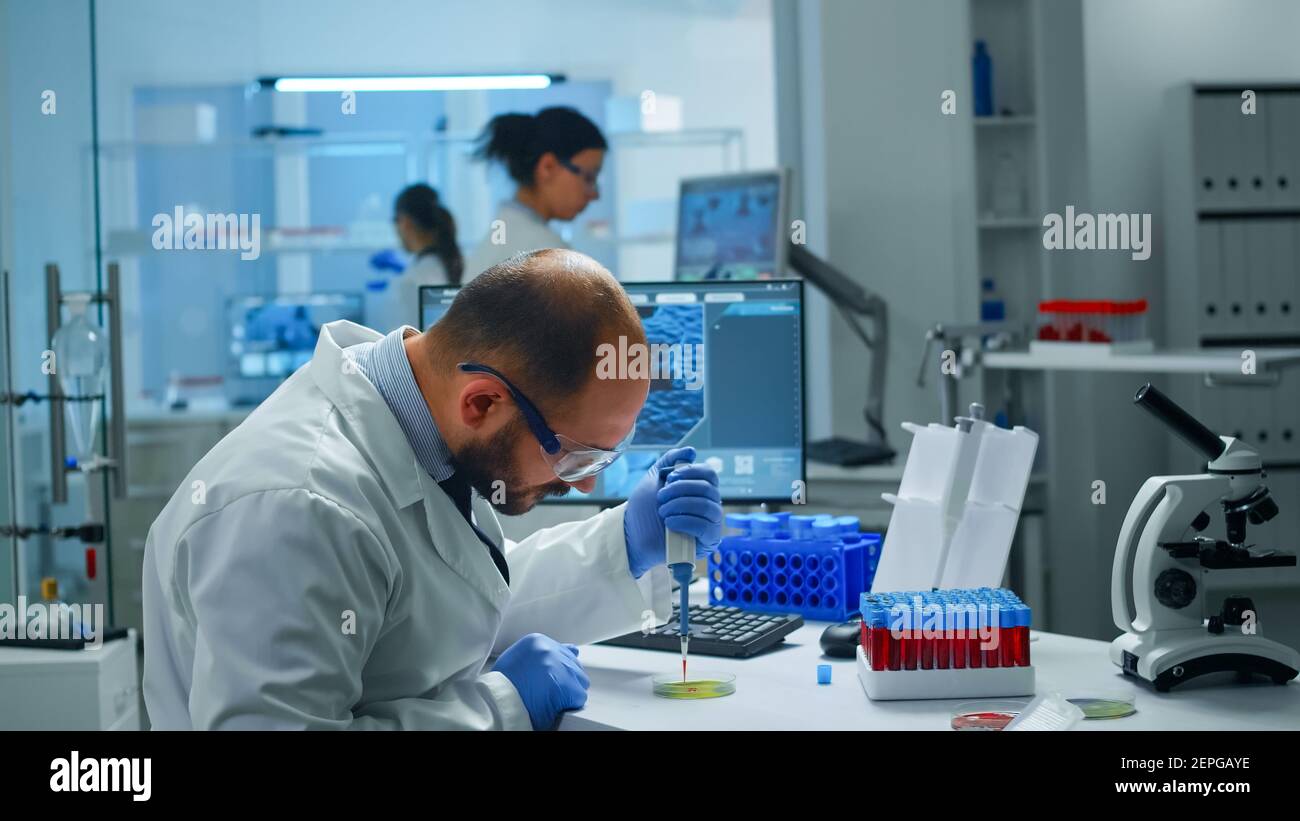 Scientist in medical laboratory examining drug discovery putting blood ...