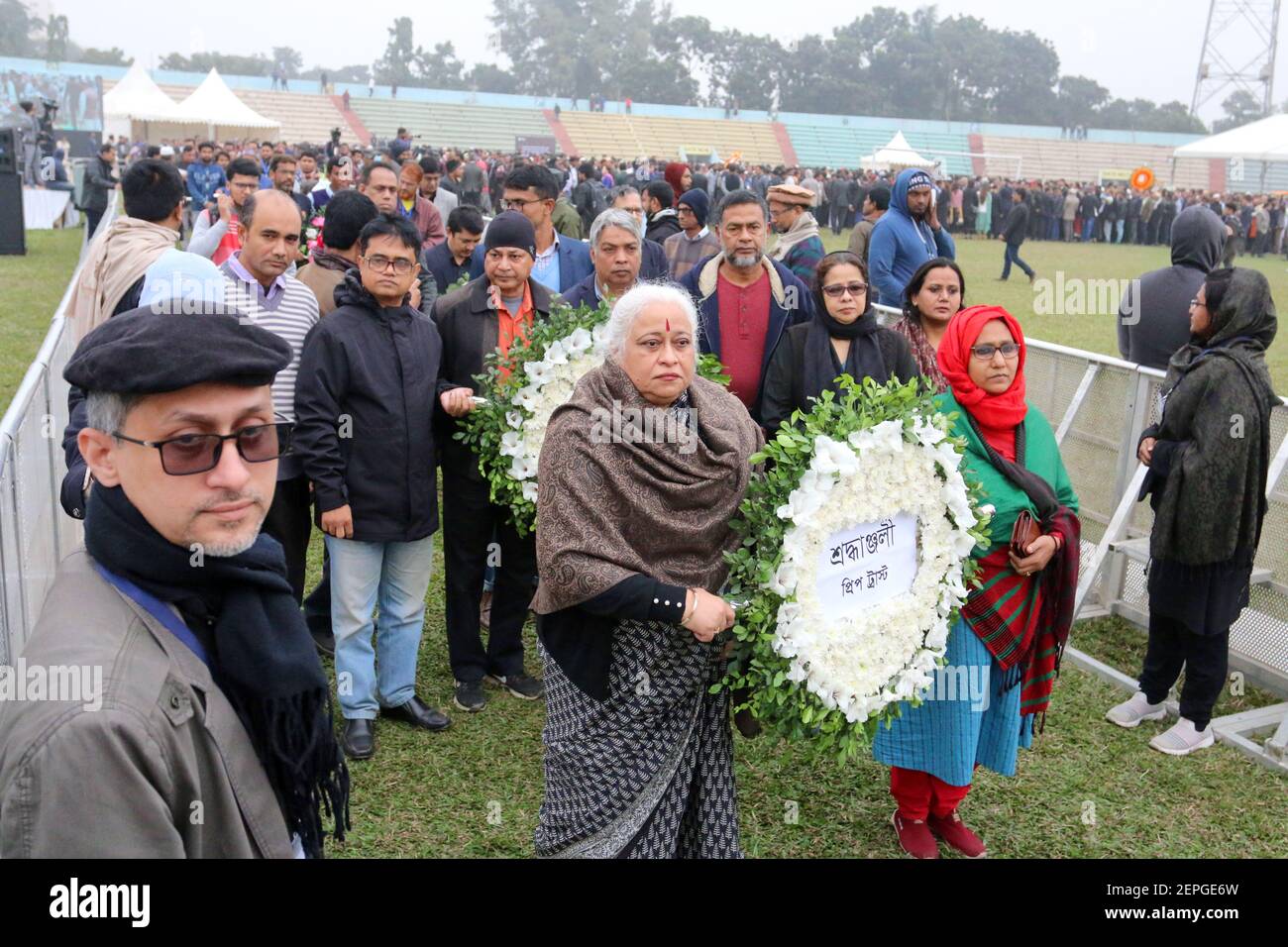 A woman carrying flowers during the ceremony at the Banani Graveyard in ...