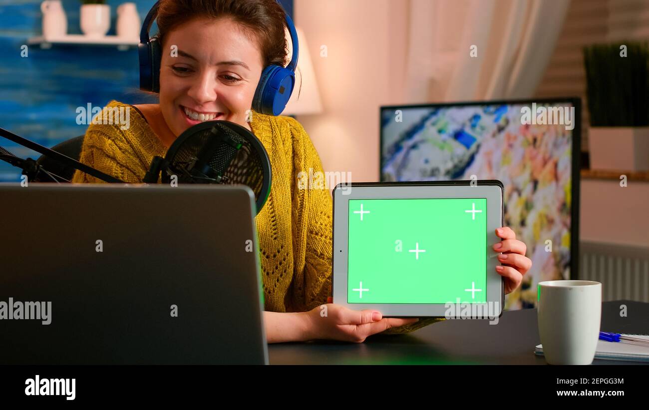 Blogger talking into microphone holding notepad with green screen ...