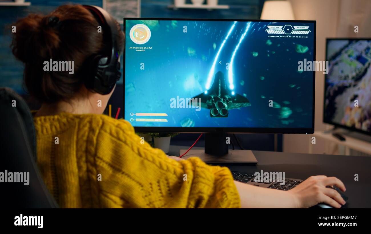 Pro gamer playing in the space shooter on personal computer. Woman ...