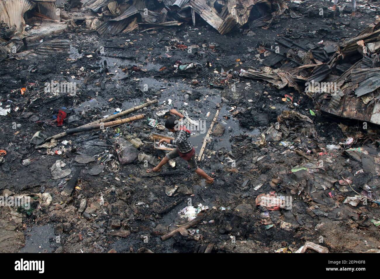 A boy walks through a fire devastated slum in Baunia badh area of Kalshi at Dhaka’s Mirpur. A ...