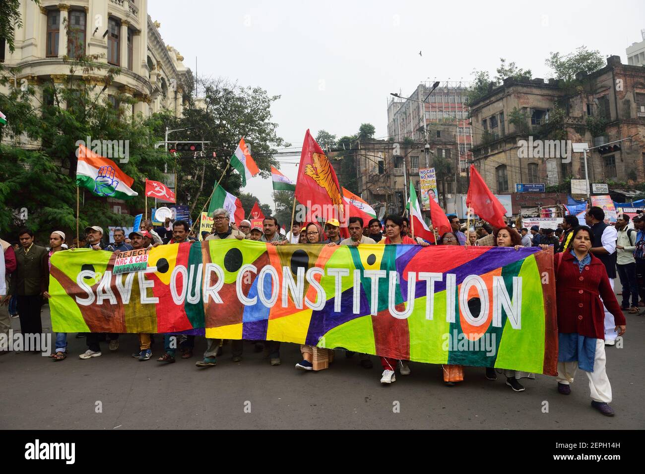 Protesters hold a banner and flags during the demonstration. Leftist ...