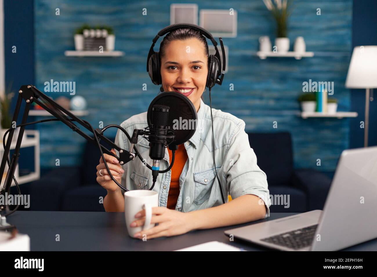 Influencer wearing headphones recording new podcast series at home ...