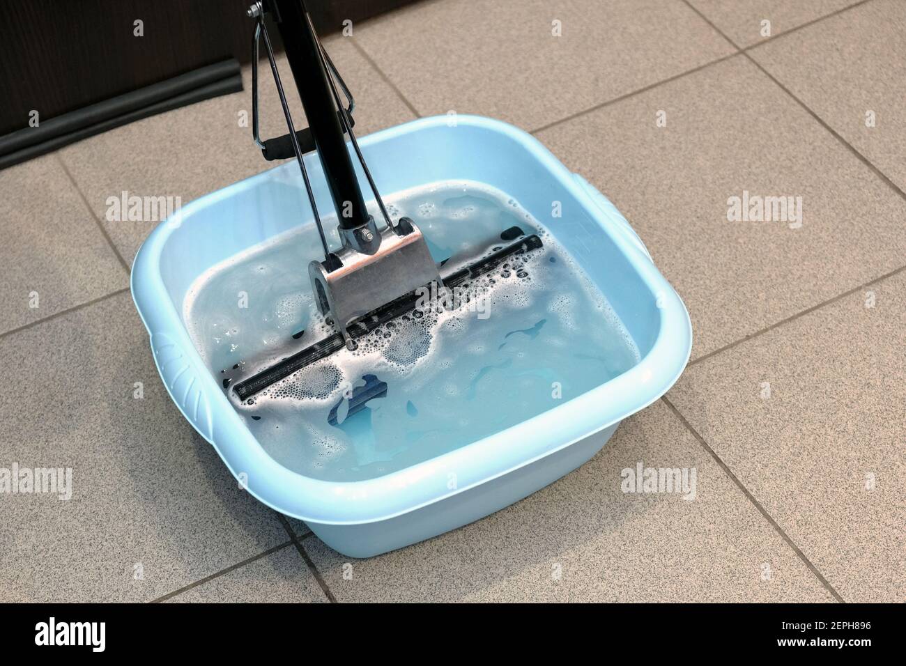 Plastic bowl with water and a mop. Soapy water with a wringer. Cleaning ...