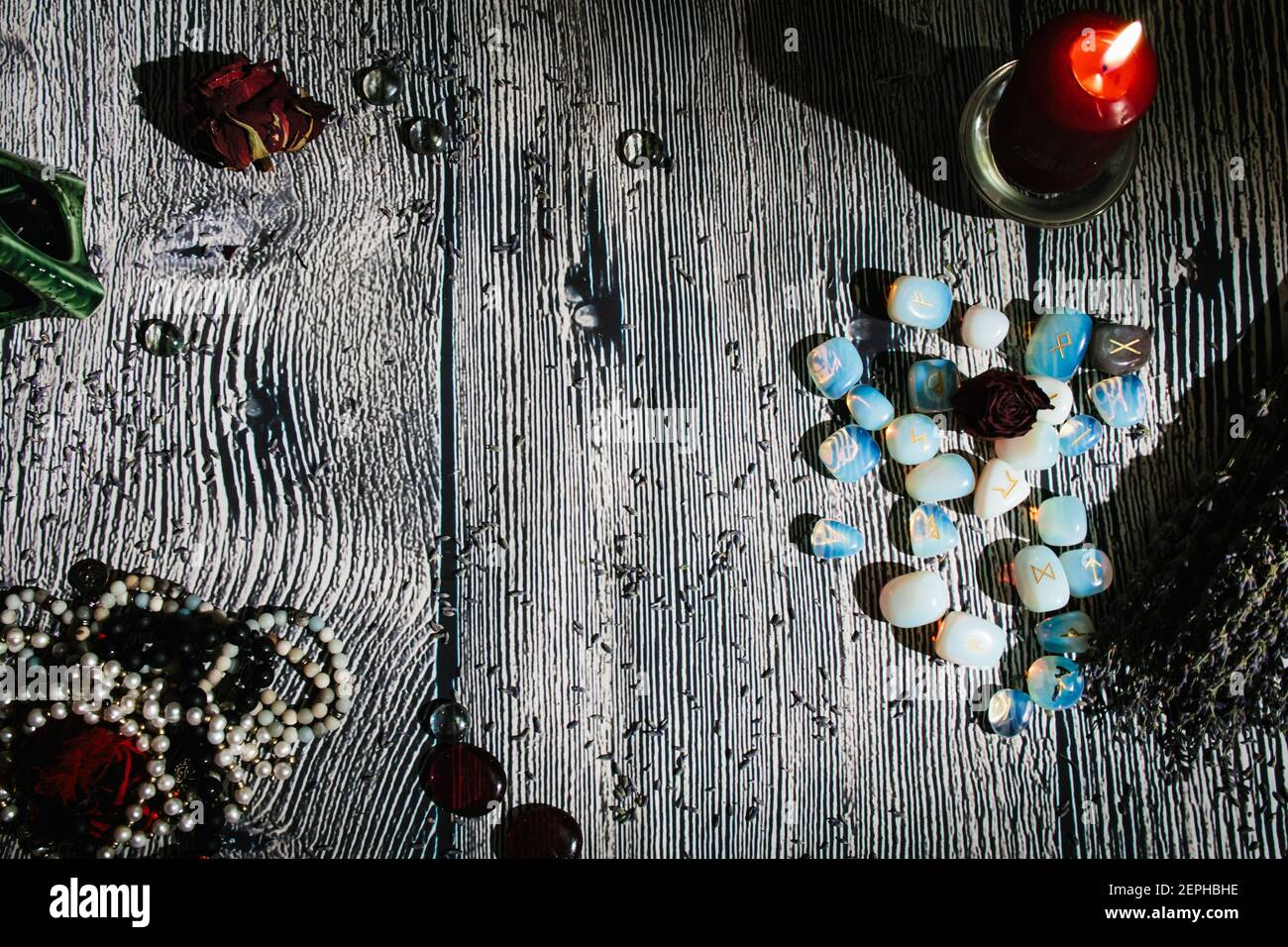 Wooden table with occult attributes, top view. Rune stones, candles ...