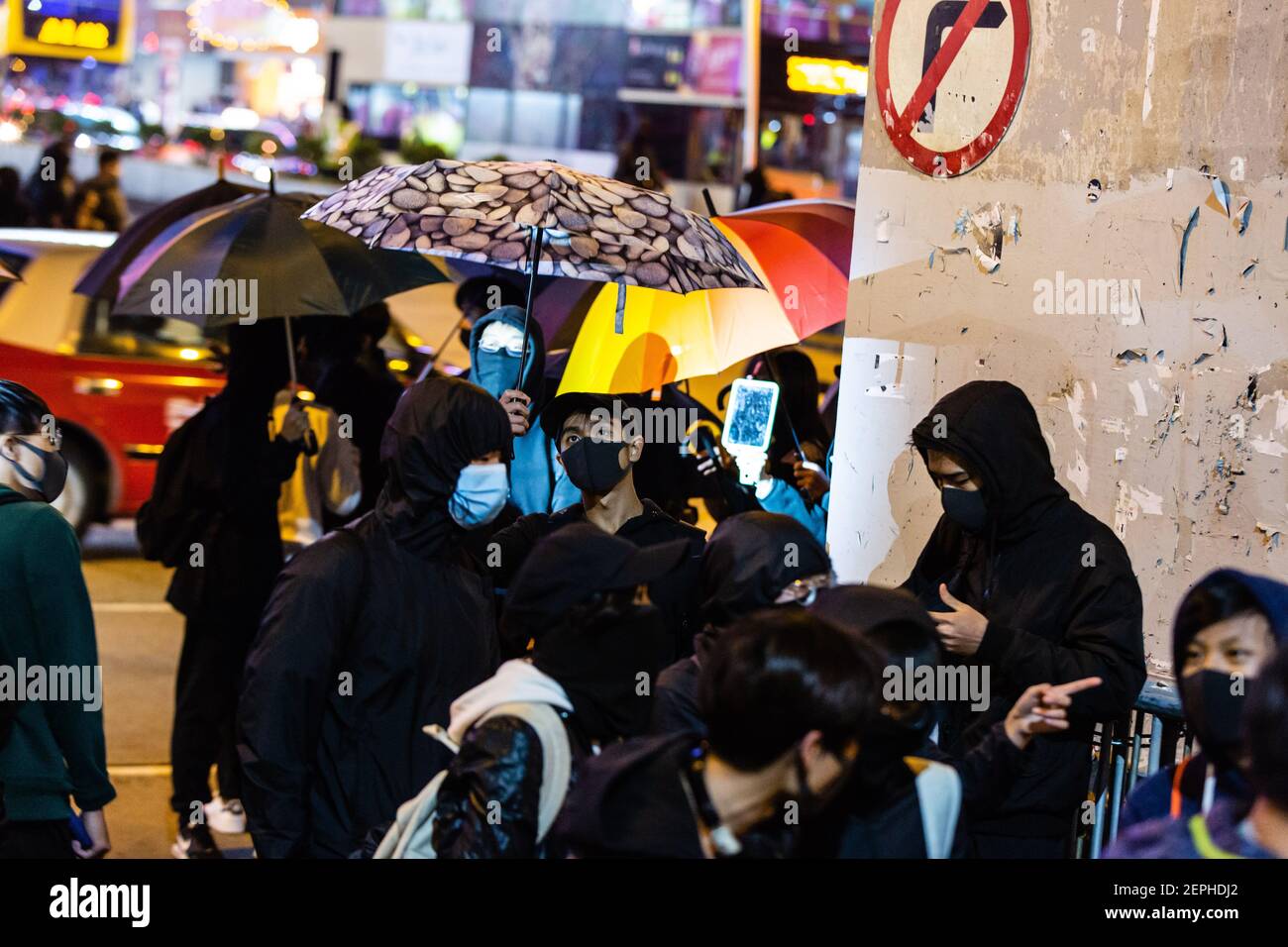 A handful of masked demonstrators staring back at police officers ...