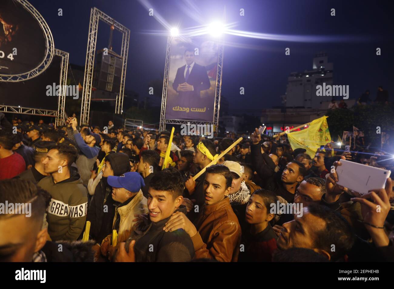 Palestinians light a torch during the celebrations marking the 55th ...