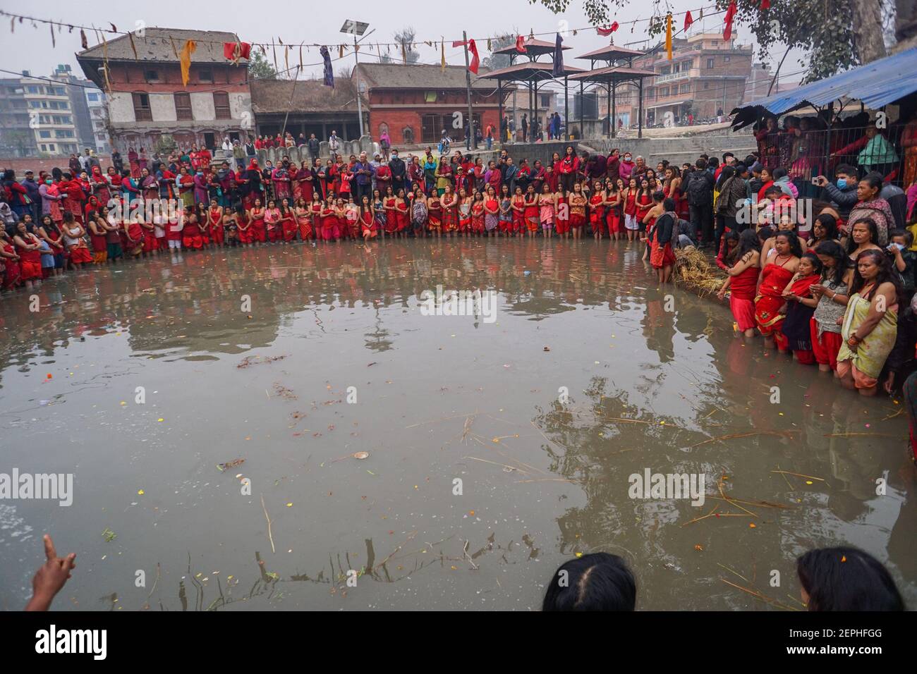 Hindu devotees stand at the bank of the Hanumante river to take part in ...