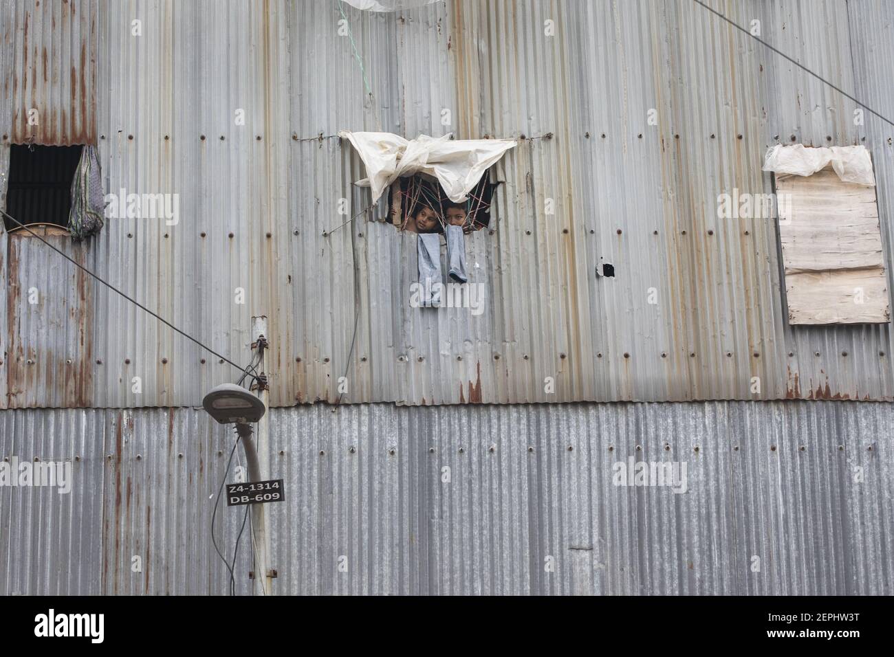 Kids are seen inside a slum window in Dhaka, Bangladesh on June 5, 2020 ...