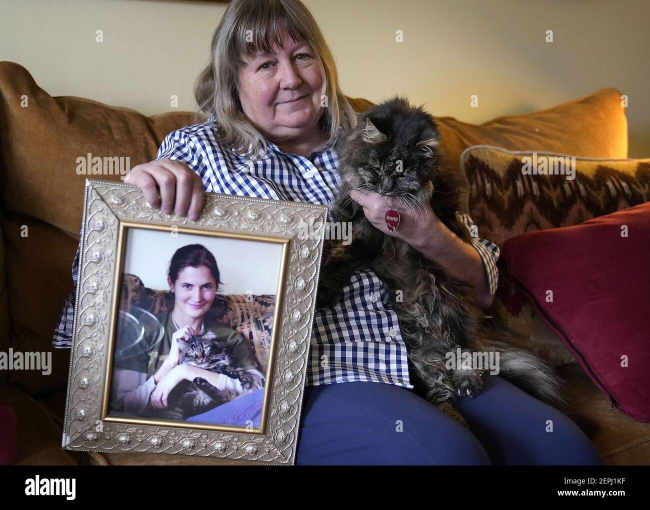 Karen Eide, Emily Hofher's mother, holds onto Shisko, a cat Emily had ...