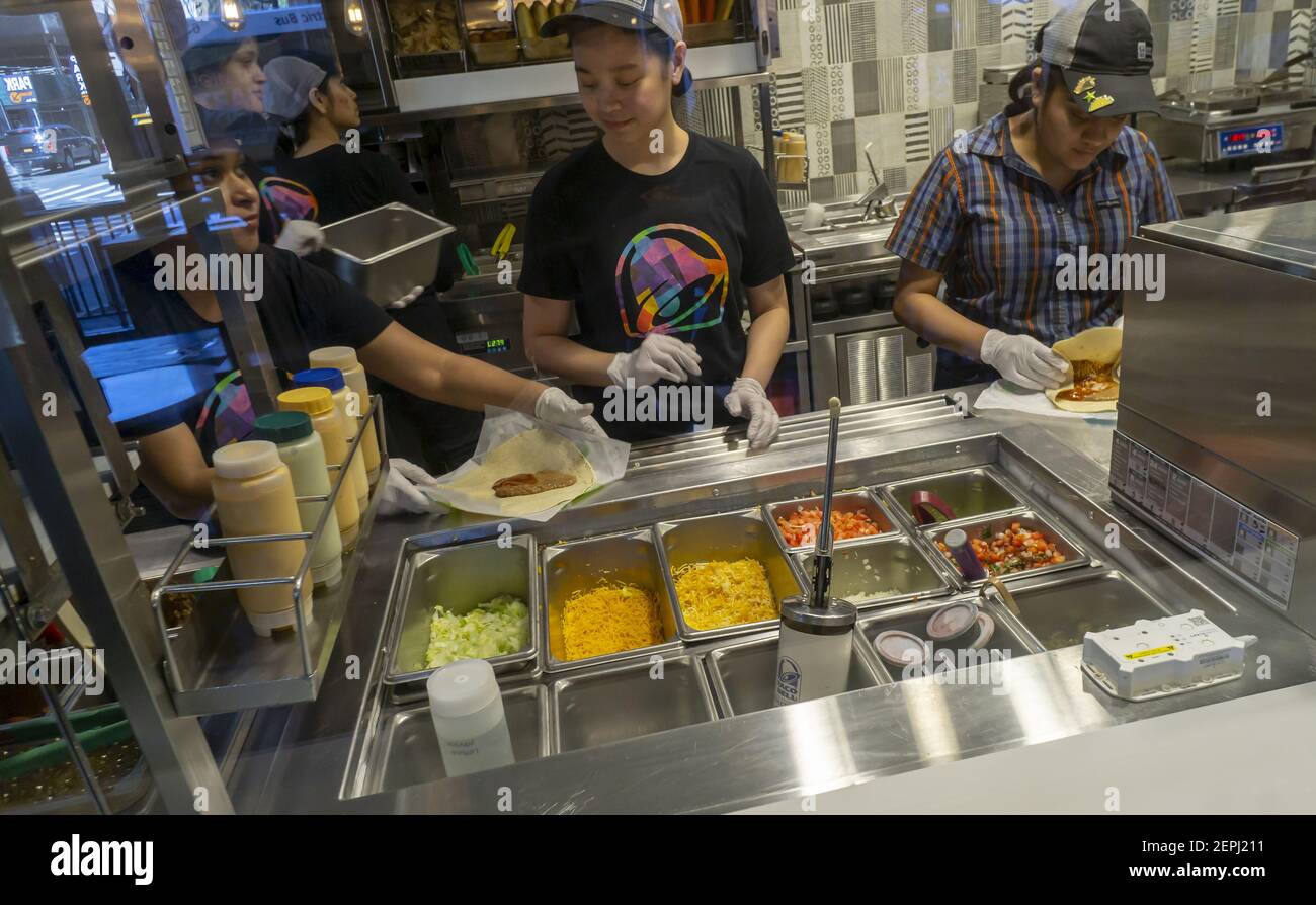 Workers prepare food in the Taco Bell Cantina restaurant in Midtown ...