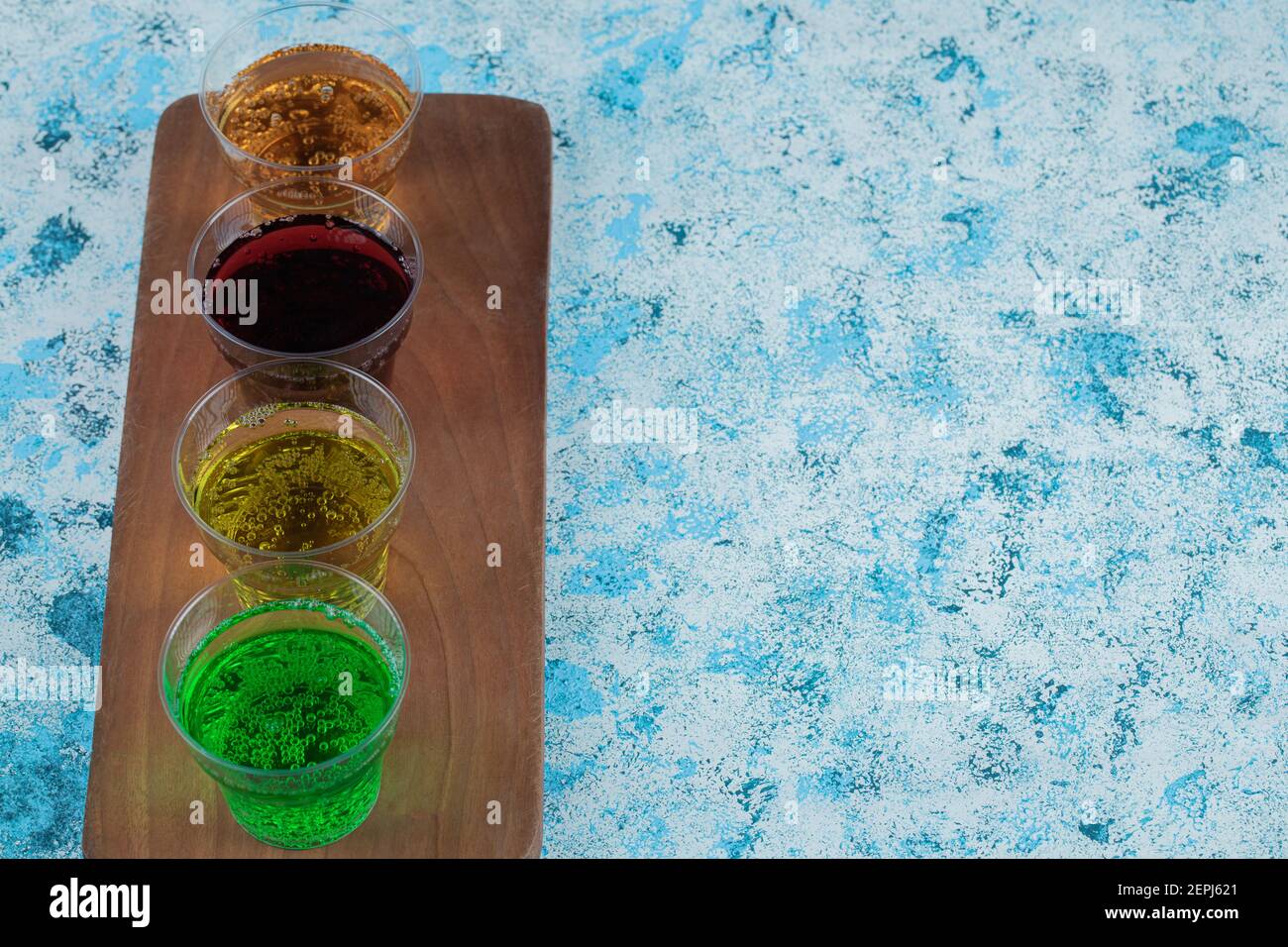 Colorful drinks in cups on a wooden platter Stock Photo - Alamy