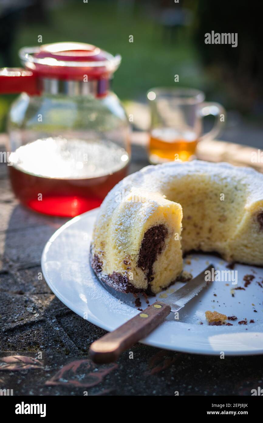 Refreshment with bundt cake and tea in garden. Morning breakfast ...