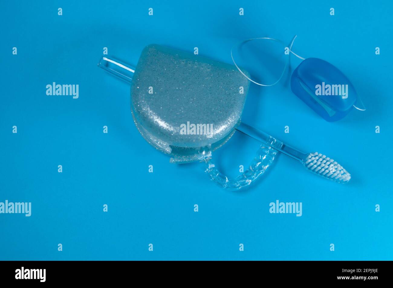 a dental splint lies in an open storage box. there is a toothbrush and ...