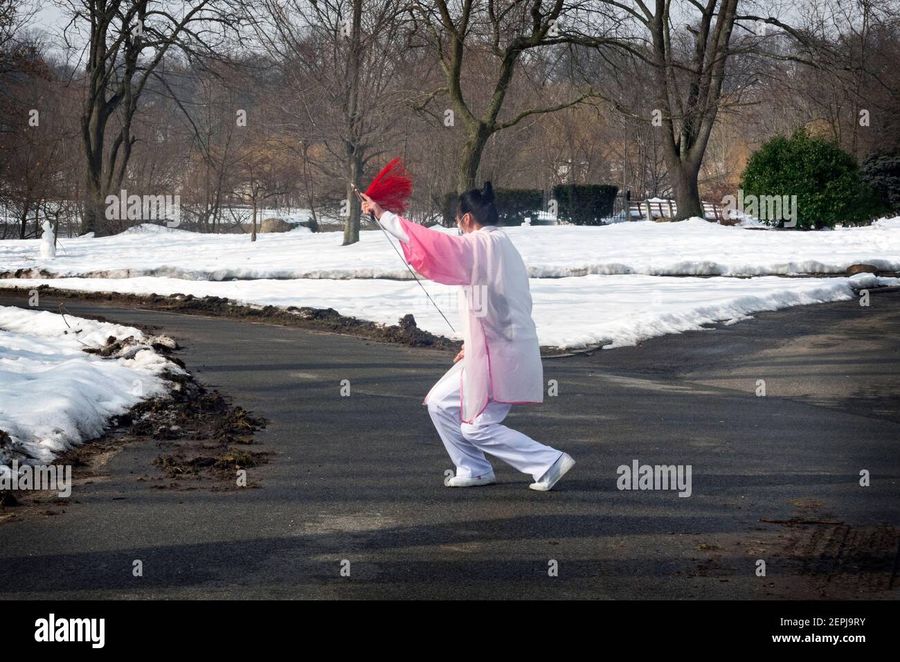 A middle aged Chinese American woman gracefully does Tai Chi dance ...