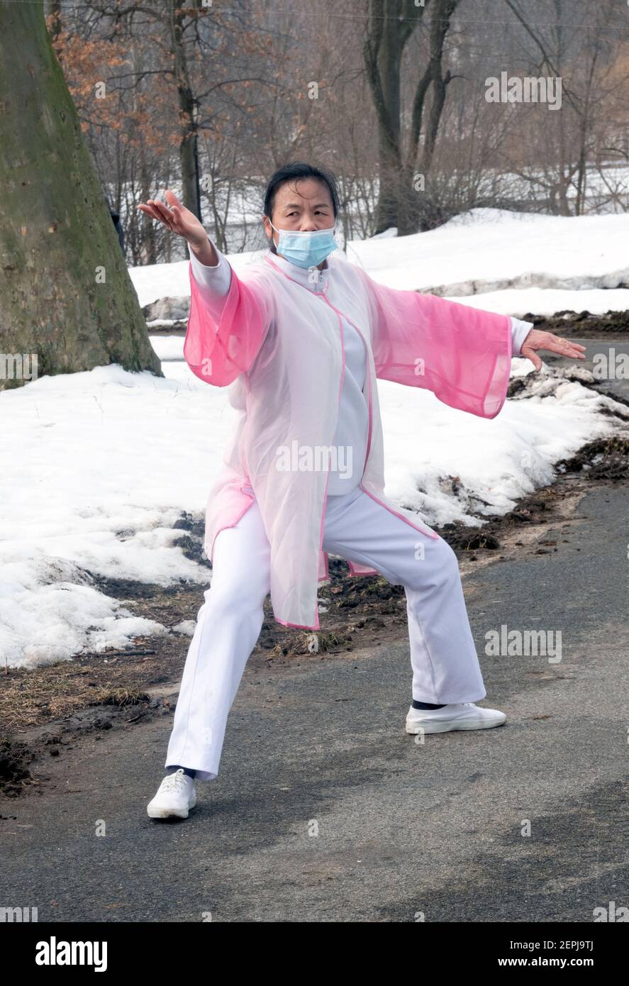A middle aged Chinese American woman gracefully does Tai Chi dance ...