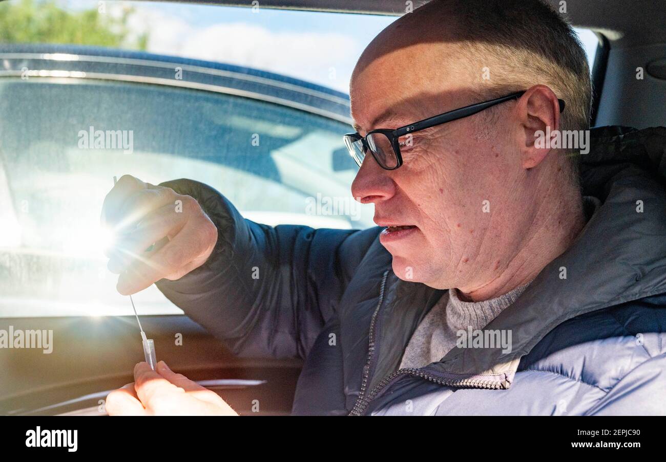 Male person using a coronavirus COVID-19 fast lateral flow self testing ...