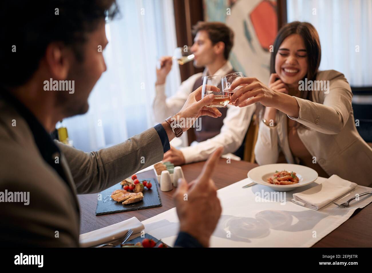 Young business people having good time at business lunch in a relaxed ...