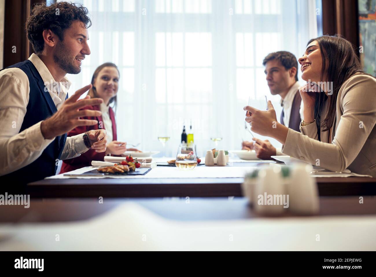 Young people talking at business lunch in a cheerful atmosphere at the ...