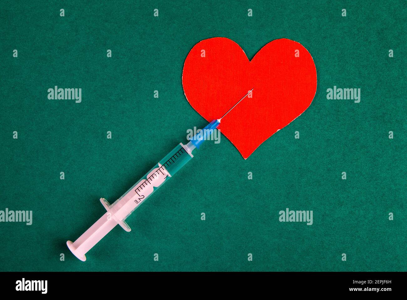 Red Heart Shape with a Syringe on the Green Background closeup Stock ...