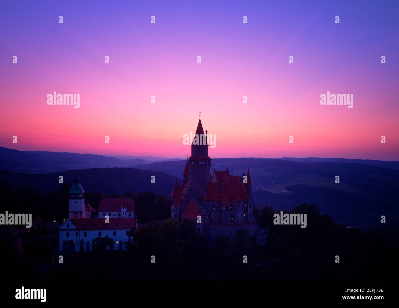 Aerial view of a silhouette of romantic fairytale castle against pink ...